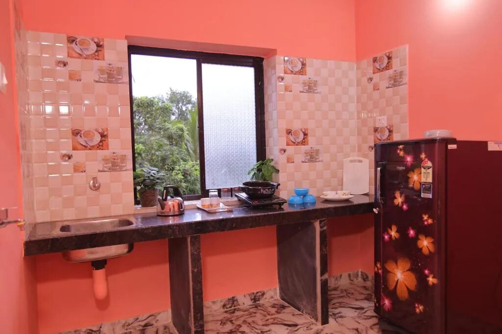 Cozinha com janela, pia, fogão e geladeira.