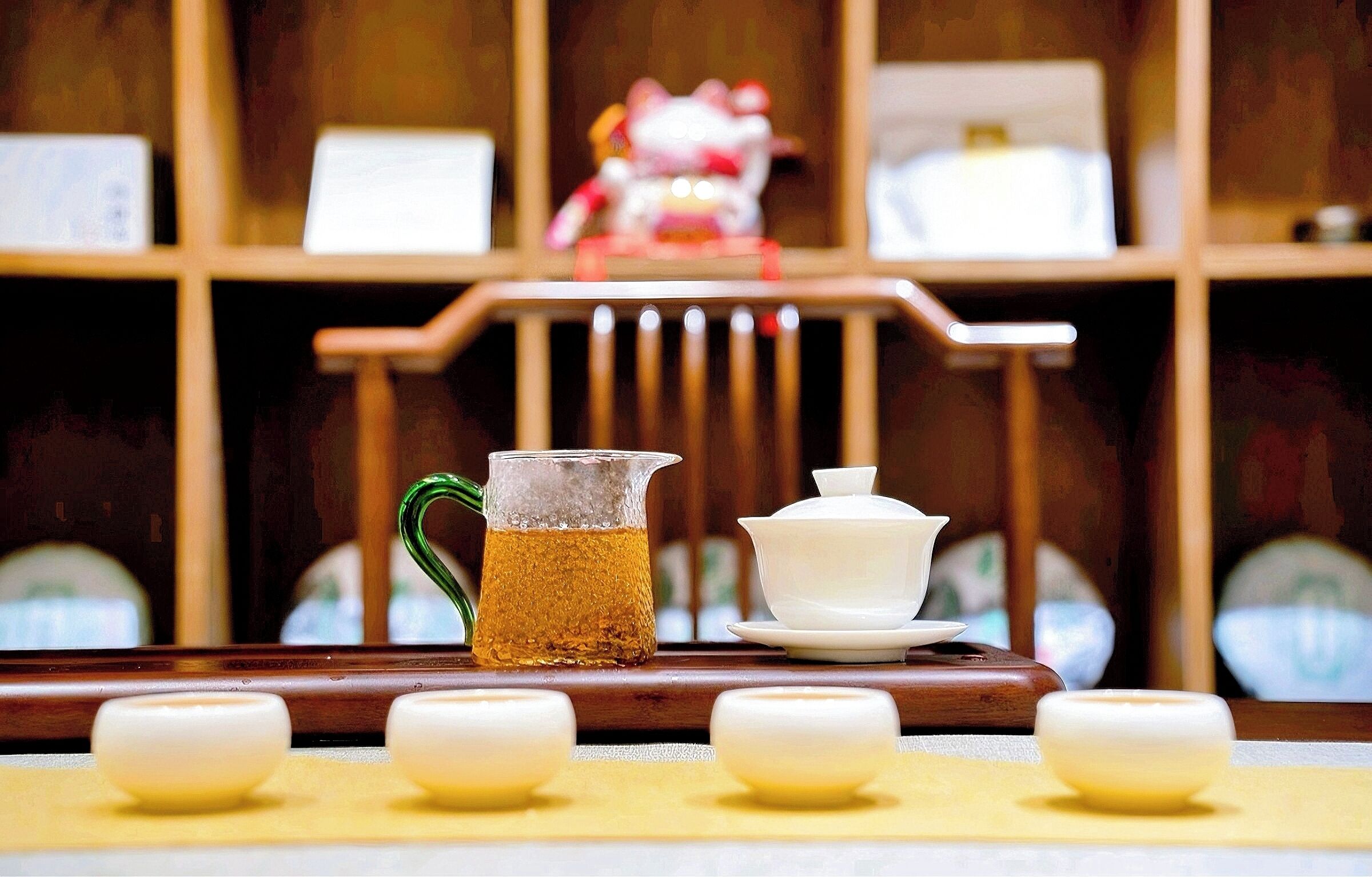 Um conjunto de chá tradicional sobre uma mesa de madeira, com bule, xícara e pires, e um jarro de chá.