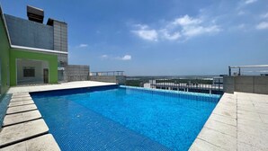 Piscina no terraço com vista clara para o horizonte da cidade.