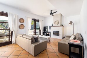 Uma sala de estar moderna com sofá, televisão e lareira.