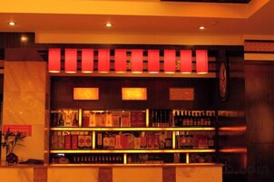 Uma área de bar com prateleiras de garrafas e um relógio na parede.