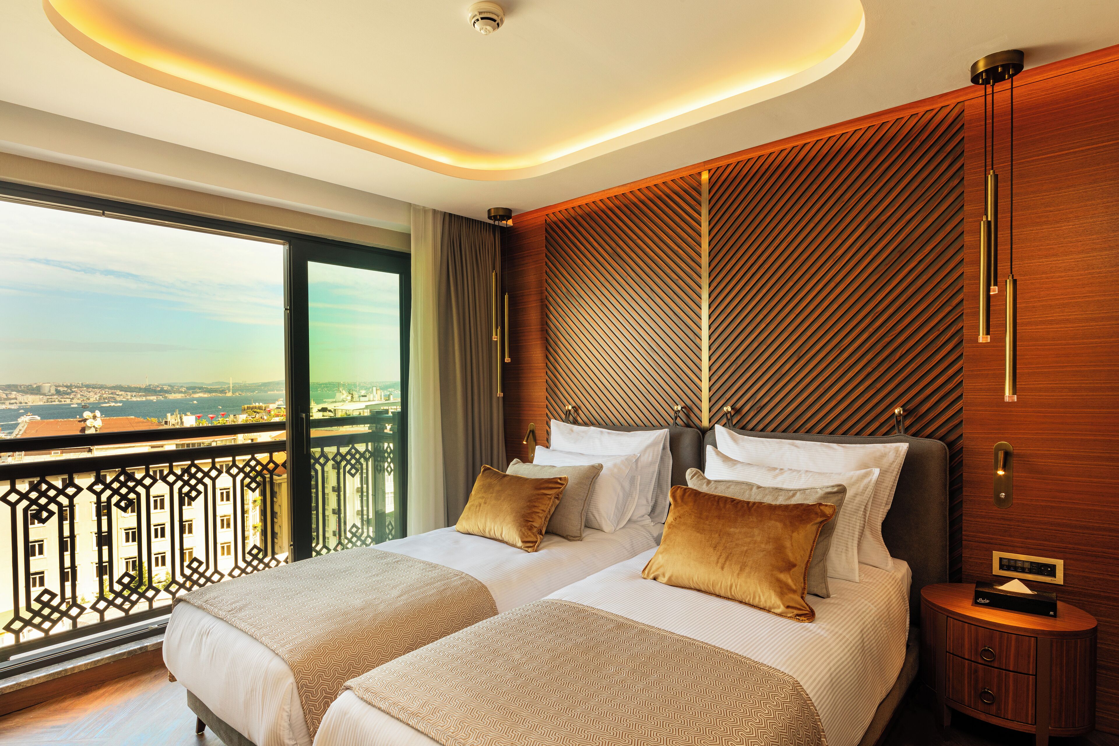 Quarto de hotel com duas camas, vista para a cidade e design moderno.
