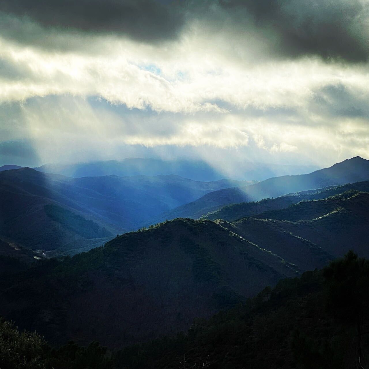 Paisagem montanhosa com vales e um rio.