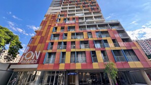 Um edifício com várias andares, fachada colorida e varandas.