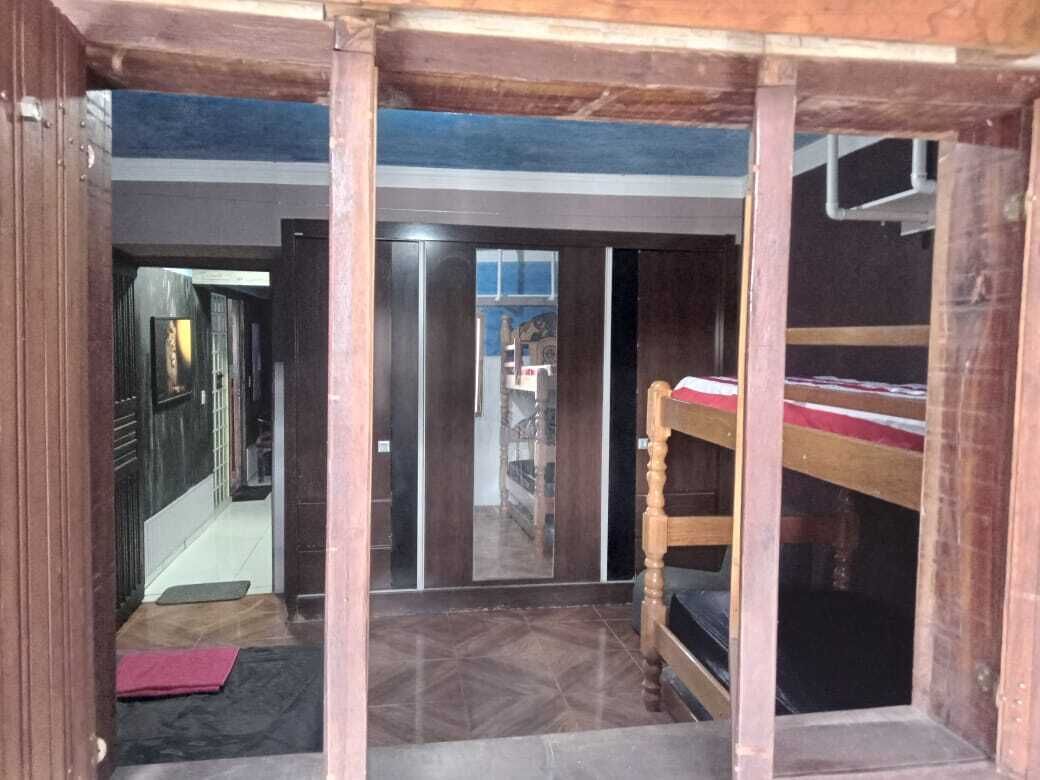 Quarto com beliche, porta deslizante e chão em azulejos.