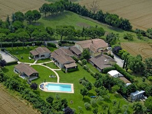 Um bairro residencial com várias casas, piscina e vegetação ao redor.