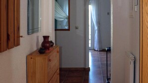 Um corredor com cômoda de madeira, espelho e ventilador de teto.