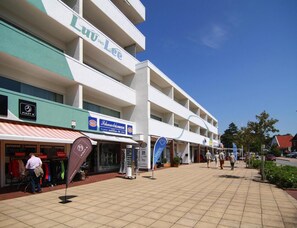 Um edifício com vários andares e diversas lojas no andar térreo, incluindo moda ao ar livre e uma loja de fósseis.