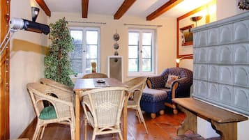 Um quarto aconchegante com teto de madeira, móveis de vime e uma grande janela.