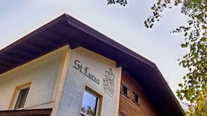 Um edifício com o nome "St. Lukas" e um brasão no fachada.