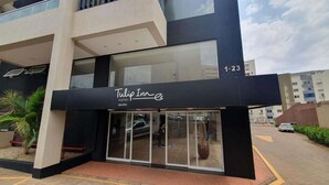 Um hotel chamado Tulip Inn, com fachada moderna, grandes janelas de vidro e entrada visível.