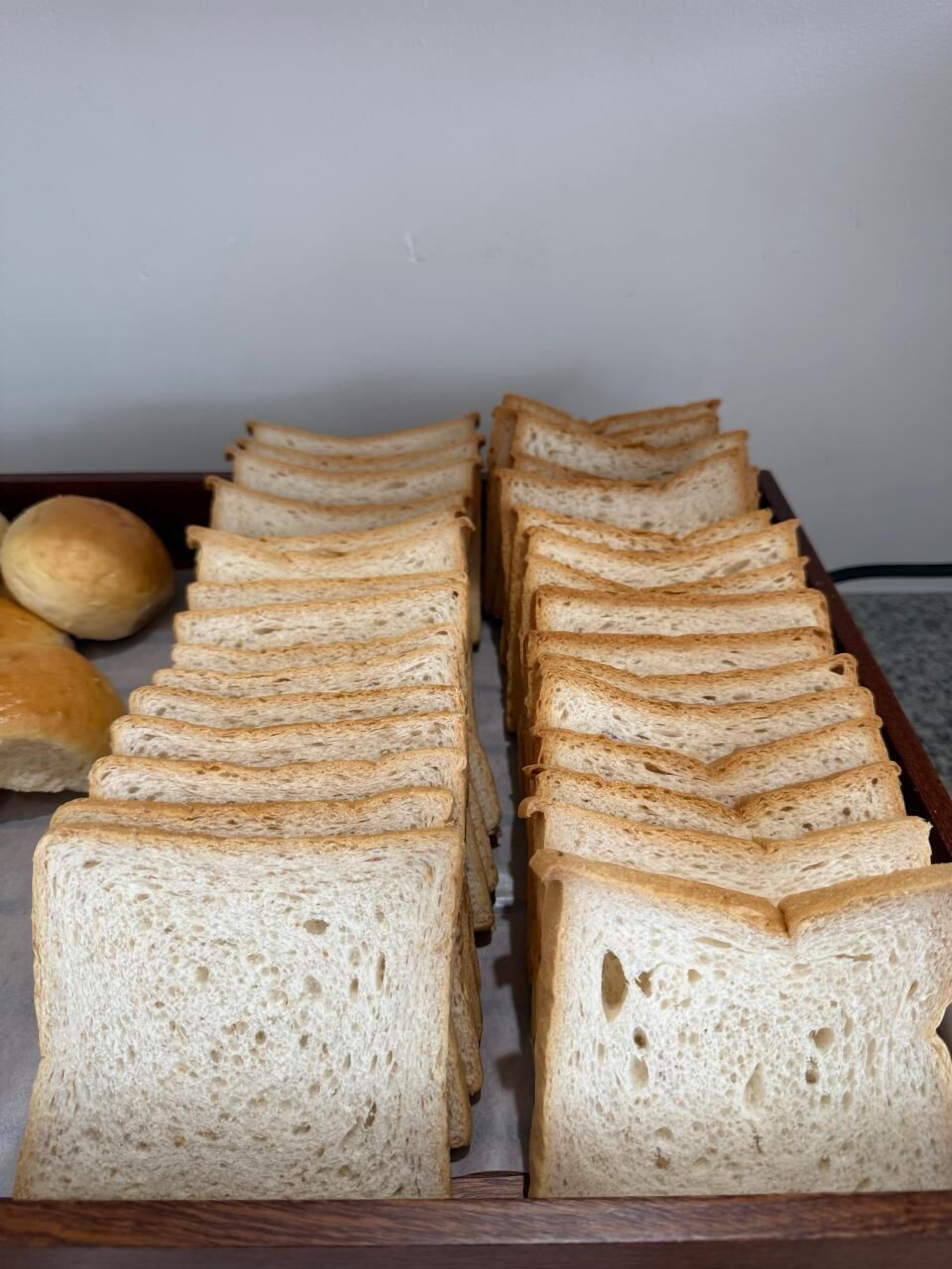 Uma travessa com fatias de pão e um pão inteiro.