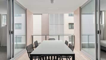 Uma sala de conferências com divisória de vidro, uma mesa longa e cadeiras.