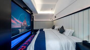 Quarto de hotel moderno com uma cama grande, televisão de tela plana e vista para um castelo.
