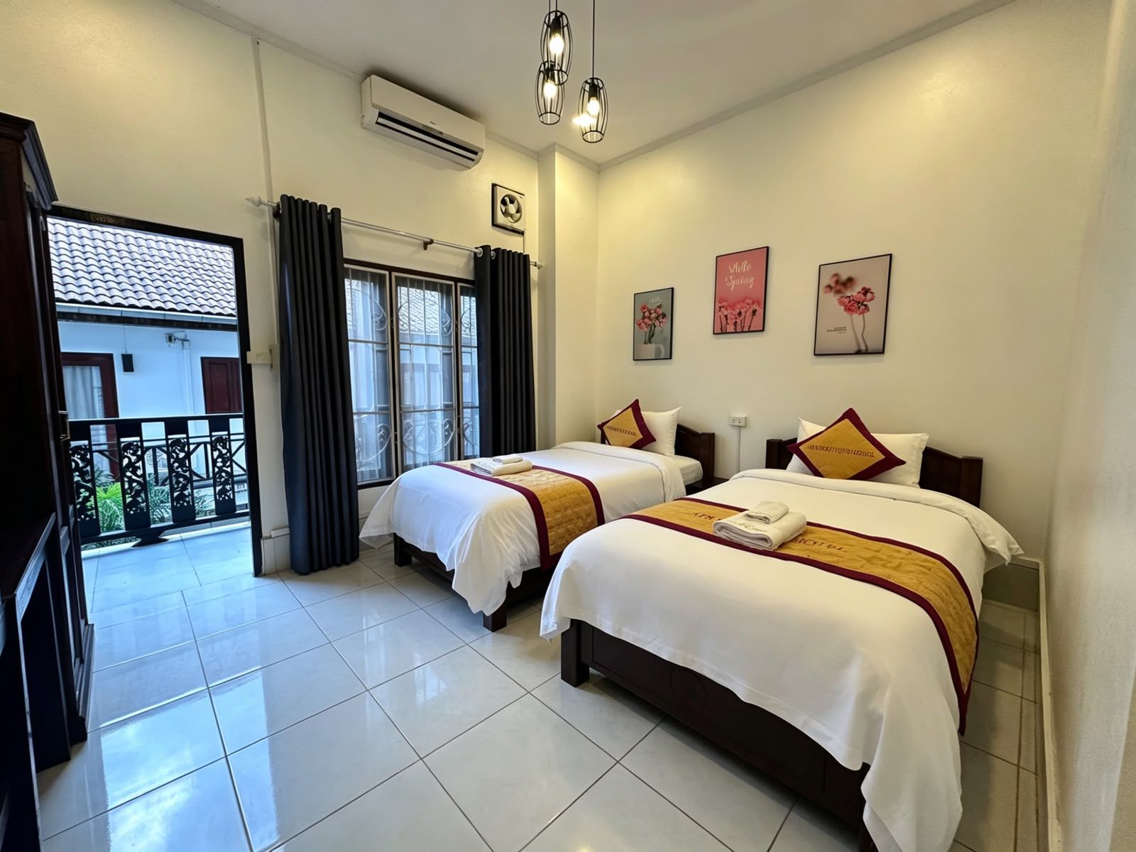 Quarto de hotel com duas camas, varanda e vista para o exterior.