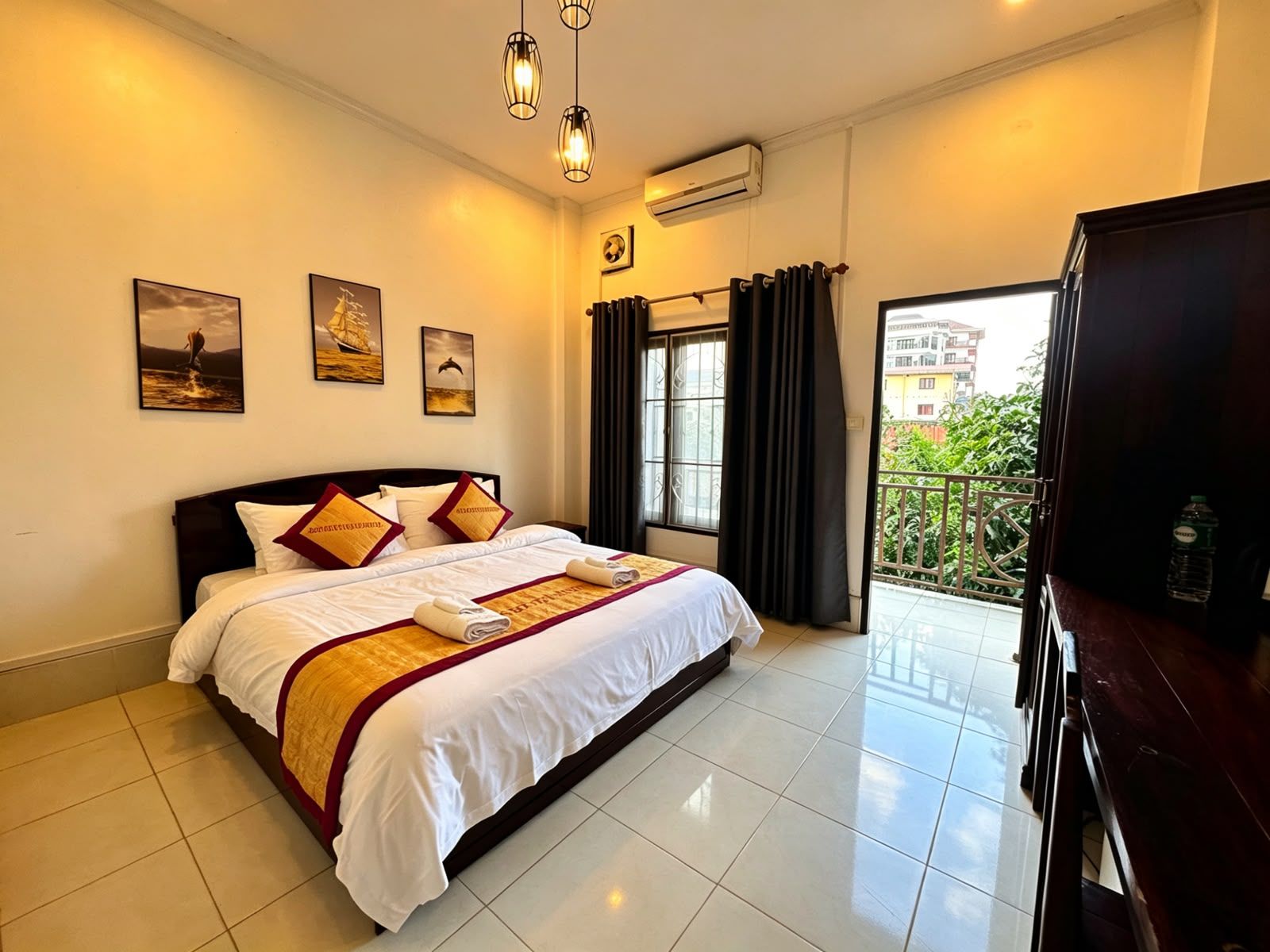 Quarto de hotel com uma cama grande, varanda e televisão.