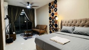 Quarto com cama, ventilador de teto, luminária na parede, sofá e vista para o exterior.