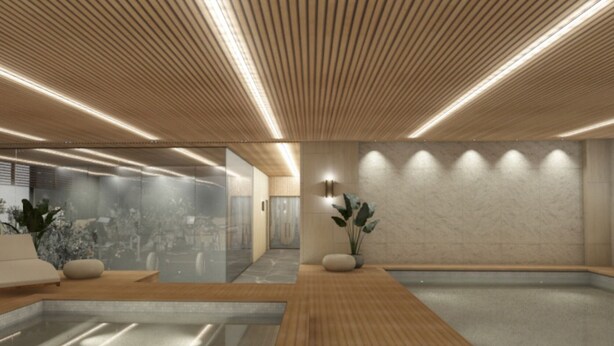 Uma área interna de piscina moderna com piso de madeira, parede de vidro e parede de pedra com luminárias.