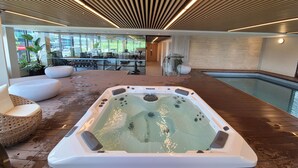 Uma área de spa com hidromassagem, assentos e vista para o exterior.