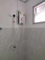 Um secador de cabelo, toalhas fornecidas, sabão, champô 