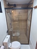 Quarto quádruplo luxo | Banheiro | Chuveiro, toalhas de banho, sabonete, papel higiênico