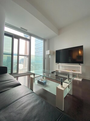 Apartamento real, vista para a cidade | Área de estar | Smart TV