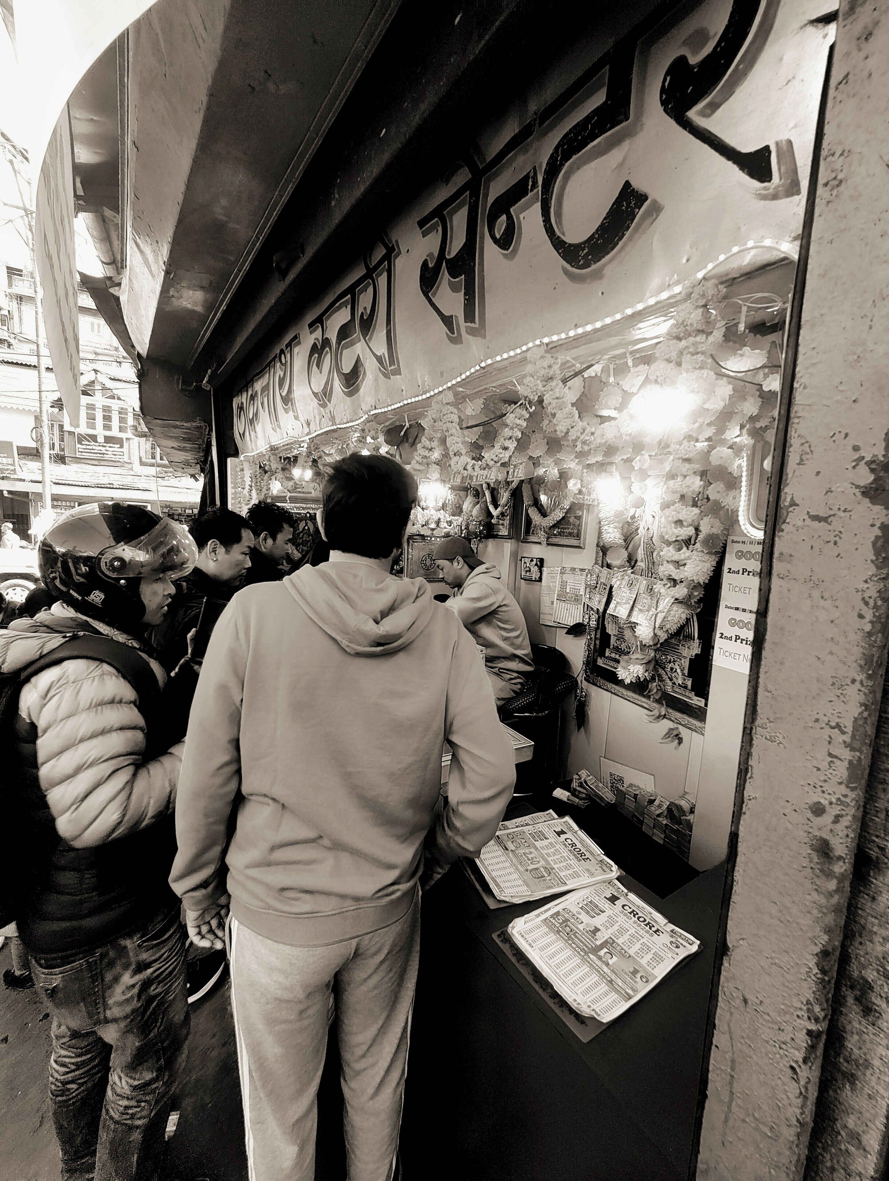 Barraca de vendedor ambulante com uma placa em escrita não inglesa, provavelmente indicando um mercado local ou área de comida de rua.