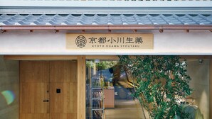 Um edifício tradicional japonês com uma placa que diz "Kyoto Ogawa Syouyaku".