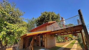 Uma pequena casa de tijolos com varanda de madeira e varanda.