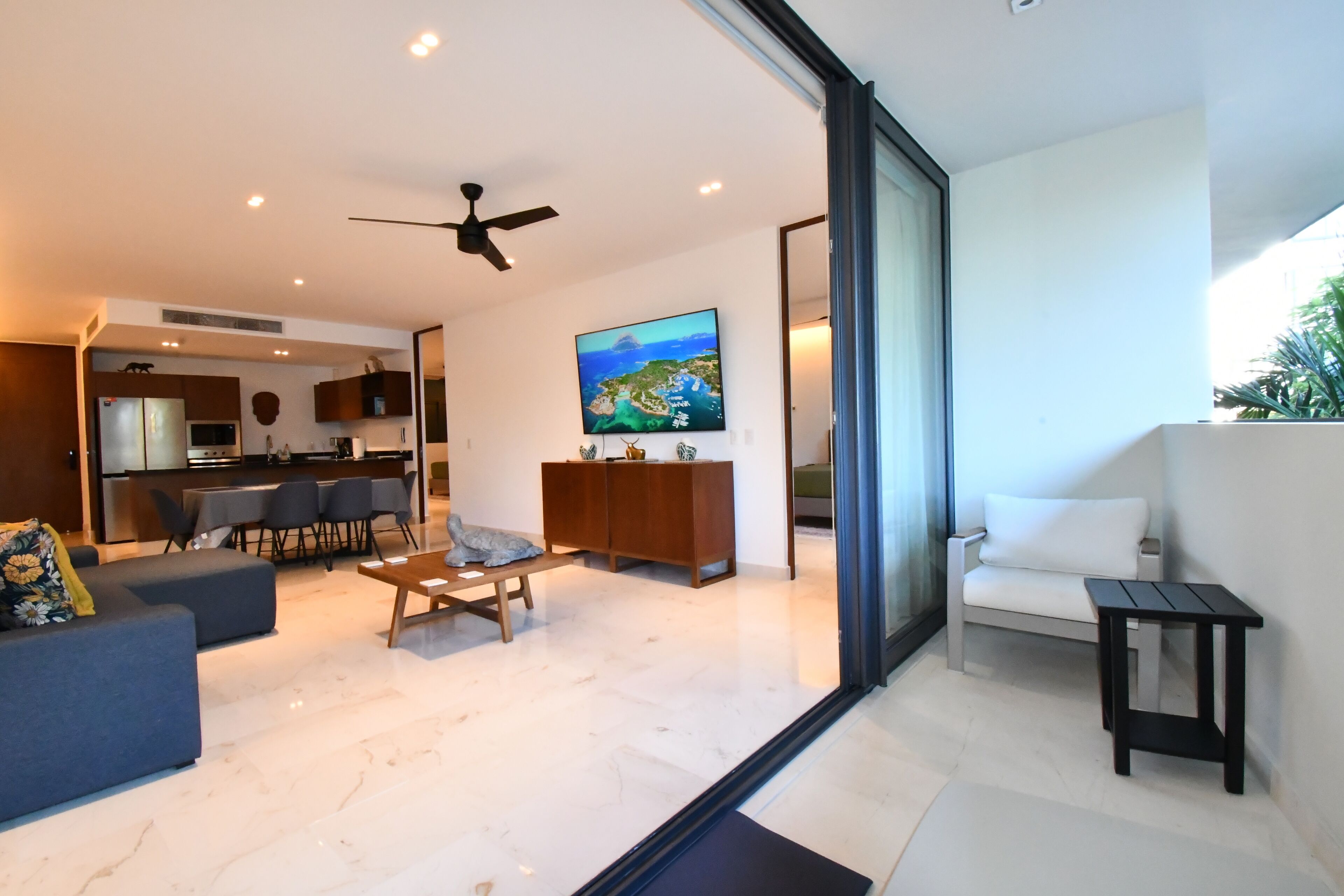 Uma sala de estar moderna com sofá, mesa de centro e televisão na parede.