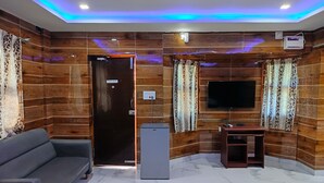 Uma sala de estar moderna com piso de mármore, um sofá, uma televisão e painéis de madeira.