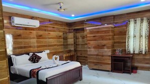 Quarto com painel de parede em madeira, uma cama com toalha em formato de coração, mesa de cabeceira e ventilador de teto.