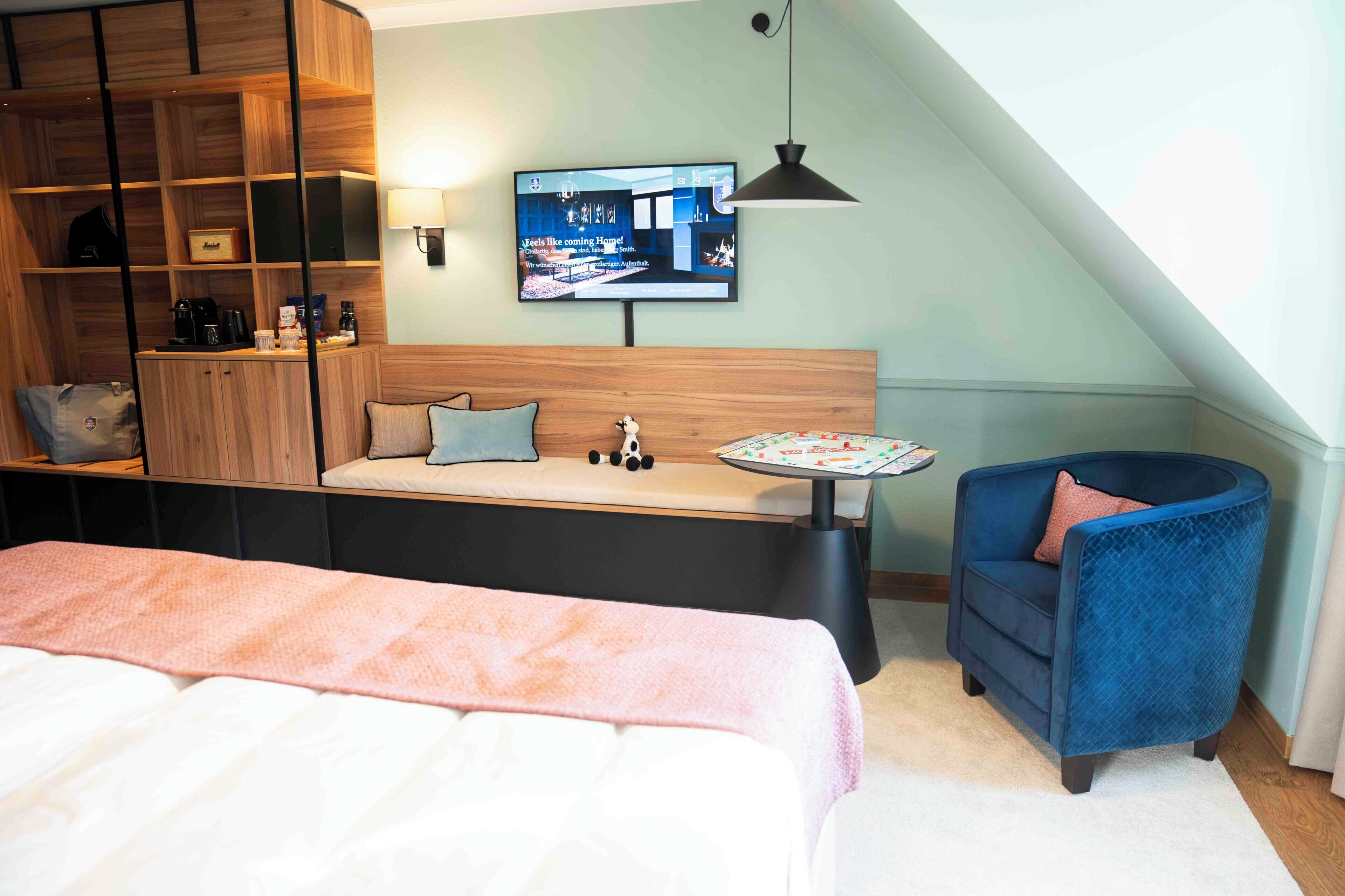 Quarto com cama, escrivaninha, cadeira, televisão e guarda-roupa.