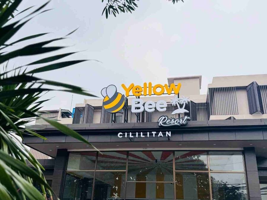 Exterior do Yellow Bee Resort, com design arquitetônico moderno, destacando o logotipo e a sinalização.
