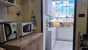 Refrigerador em uma área comum, micro-ondas em uma área comum