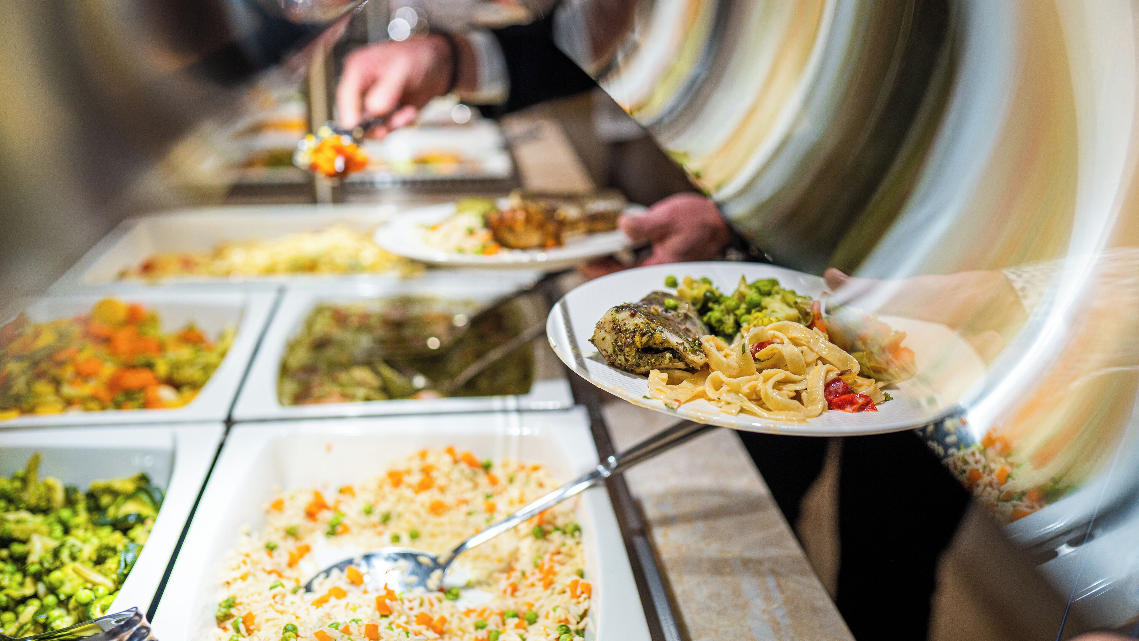 Buffet com diversos pratos, incluindo massa, legumes e arroz.
