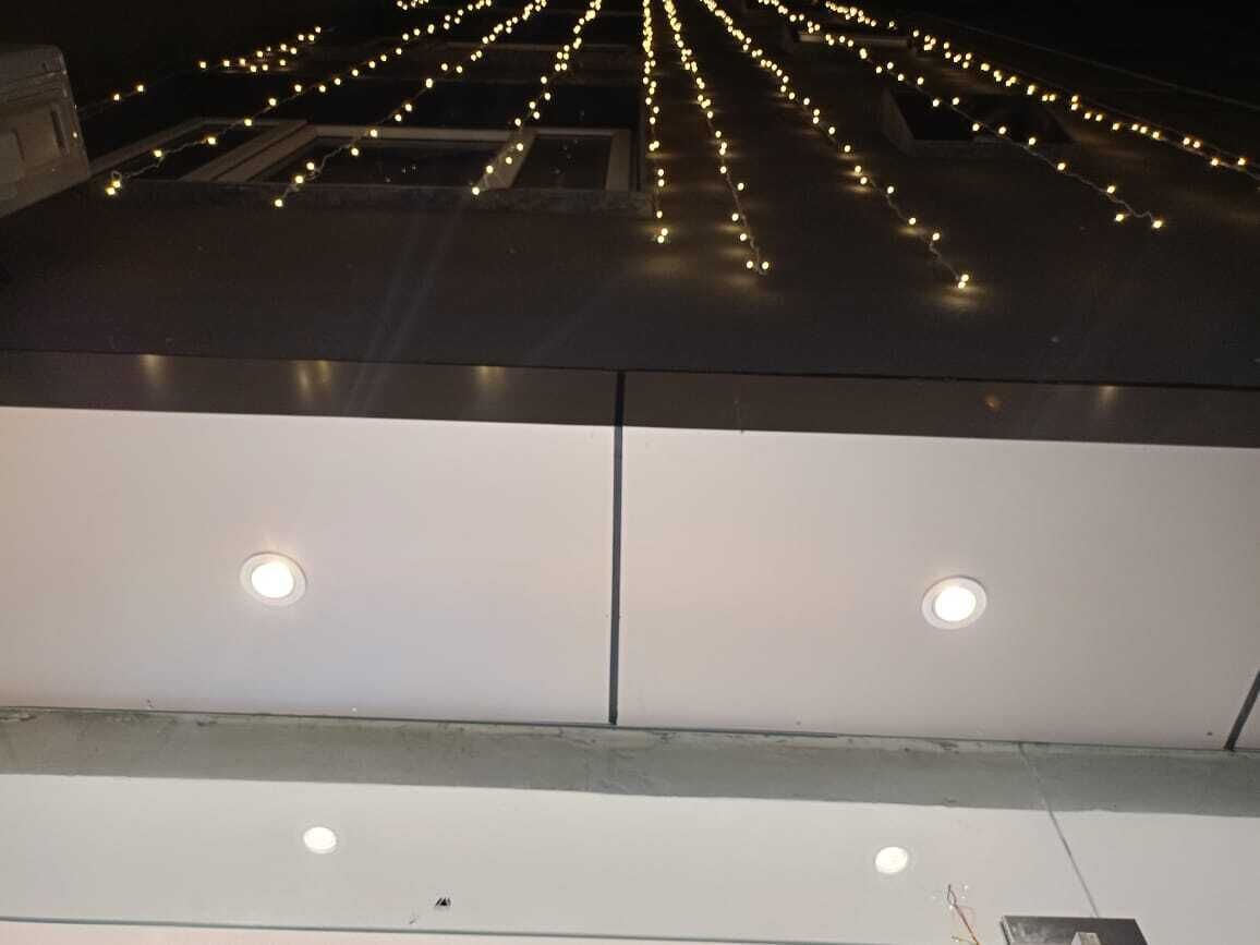Um edifício moderno com telhado plano e uma série de luzes dispostas em padrão.