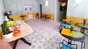 Uma área de refeições com uma mesa de mármore, cadeiras e um chão estampado.