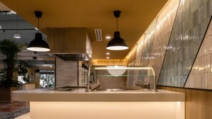 Um banheiro moderno com uma pia central, duas luminárias pendentes e ladrilhos estampados nas paredes e no chão.
