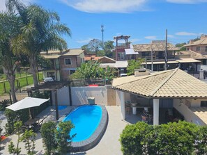 Uma área residencial com piscina, espaço para sentar ao ar livre e um gazebo.