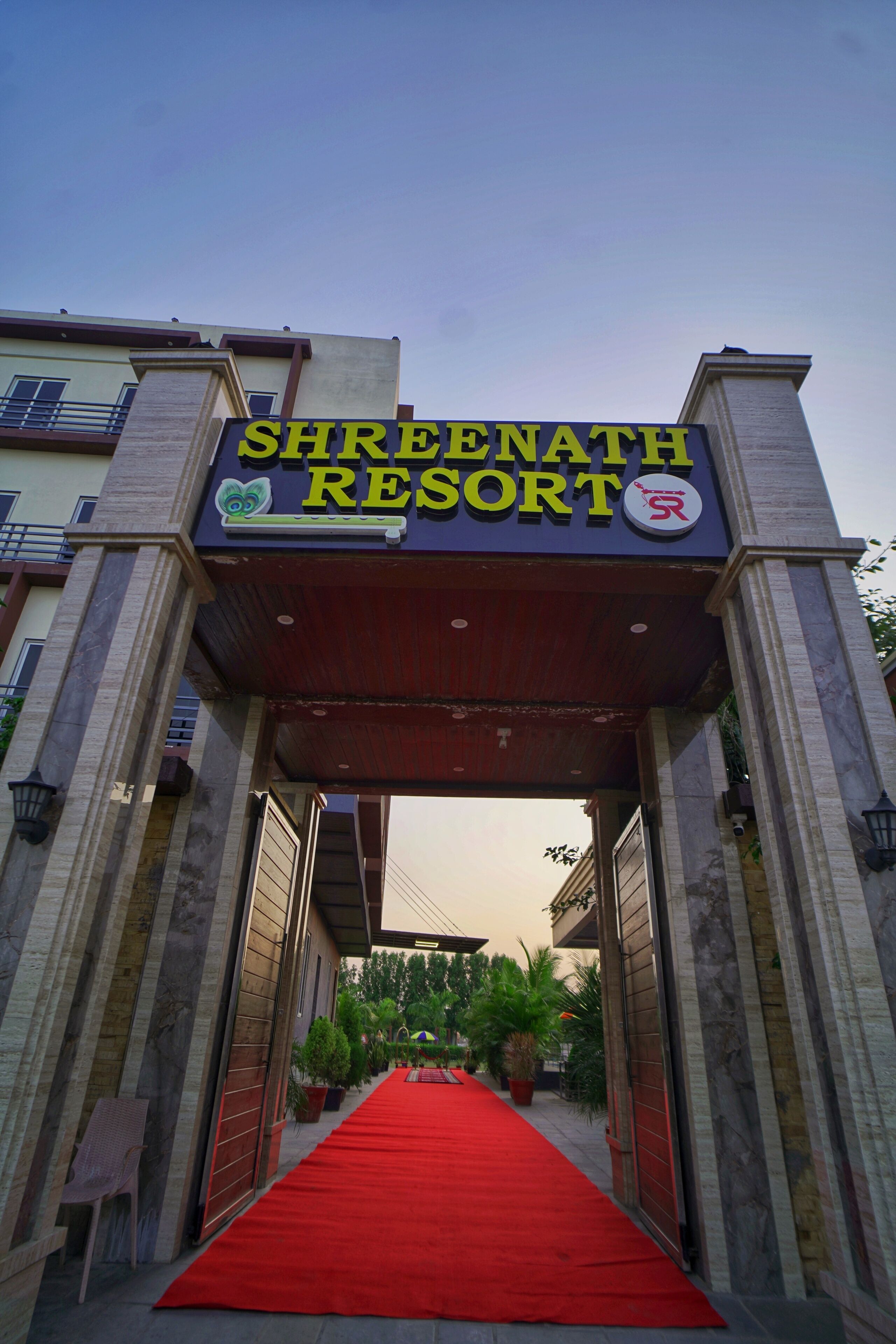 A entrada do Shreenath Resort, com um tapete vermelho que leva ao edifício principal.