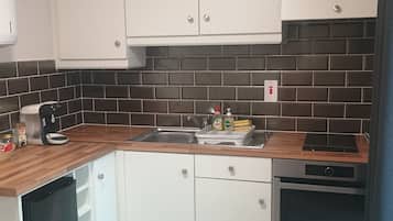 Apartamento conforto, varanda | Cozinha privada | Frigobar, micro-ondas, fogão, cooktop