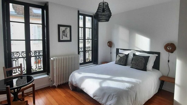 Quarto com cama grande, mesa de jantar e cadeiras.