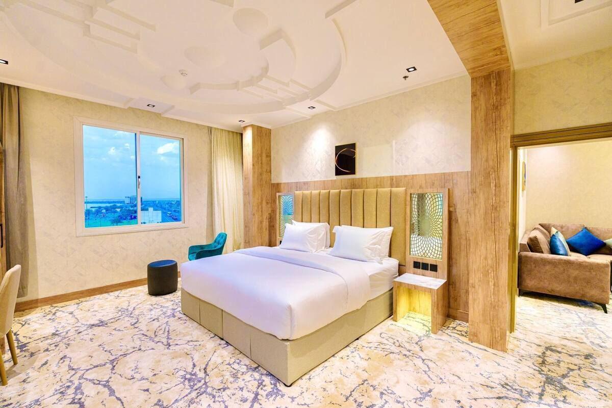 Quarto de hotel espaçoso com uma cama grande, vista para a cidade e design moderno.
