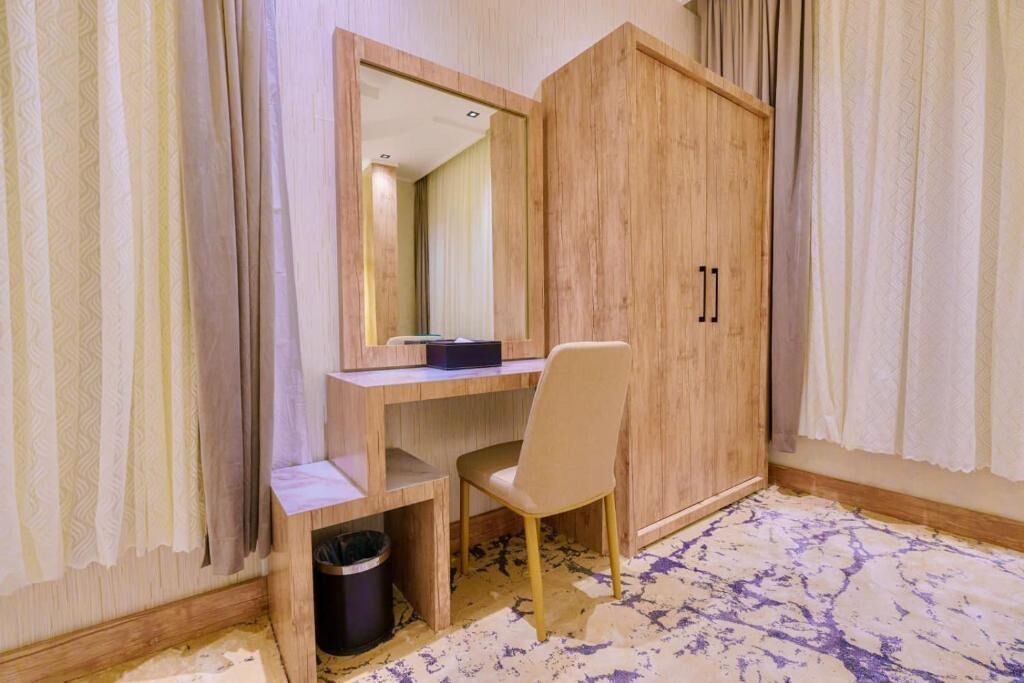 Quarto com escrivaninha de madeira, cadeira e guarda-roupa.