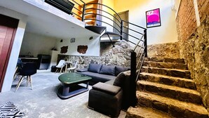 Uma sala de estar espaçosa com uma escadaria moderna, uma área de refeições e uma cozinha.