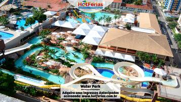 Um parque aquático com várias piscinas, toboáguas e guarda-sóis.