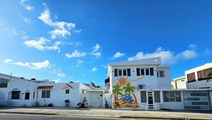 Um edifício branco com um mural que retrata uma cena de praia.