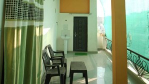 Quarto com ventoinha no teto, porta, janela e varanda.