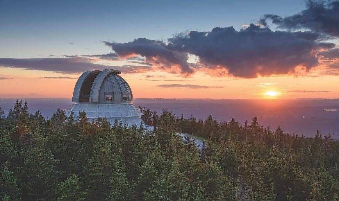 Um observatório abobadado cercado por uma floresta densa.